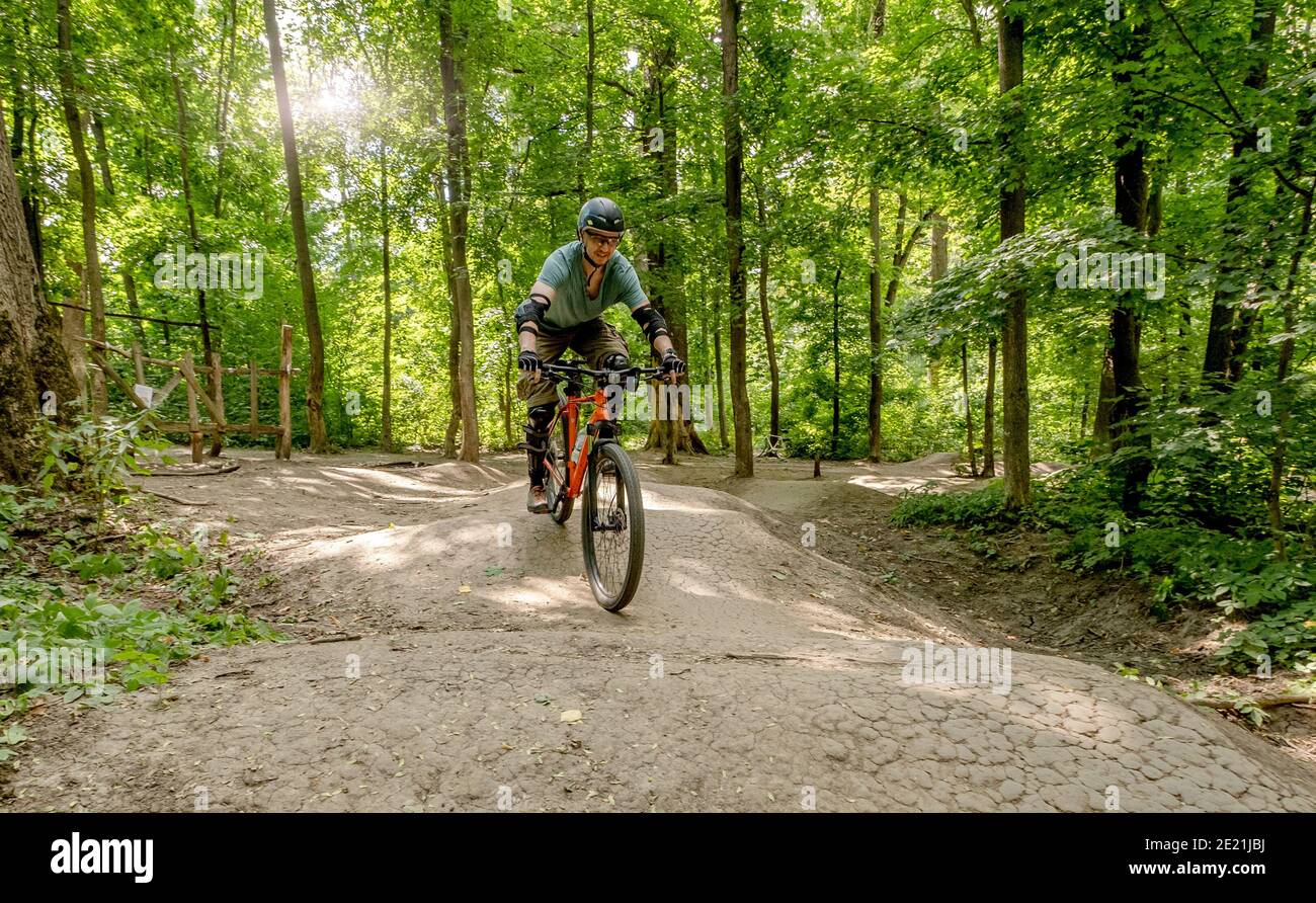 Man riding bicycle on forest road Stock Photo - Alamy