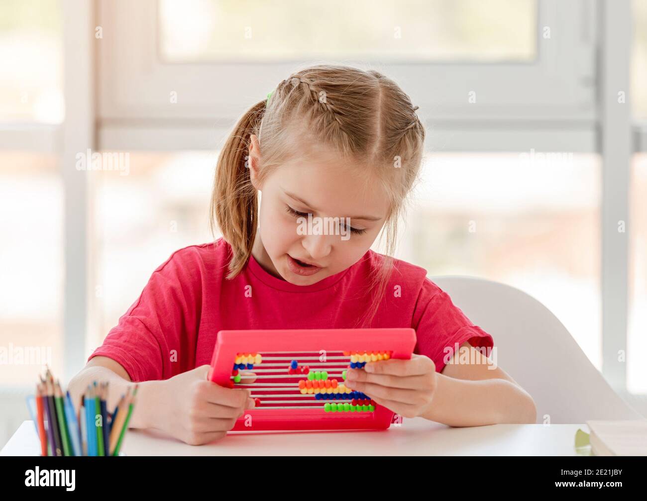 Little girl counting on abacus sitting at desk at school Stock Photo ...