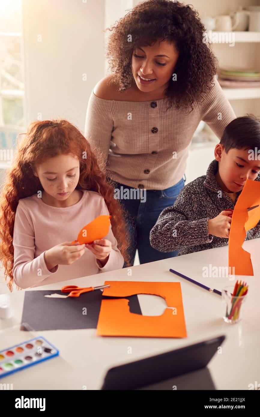 Two Children At Home With Mother Having Fun Making Craft Together Stock ...