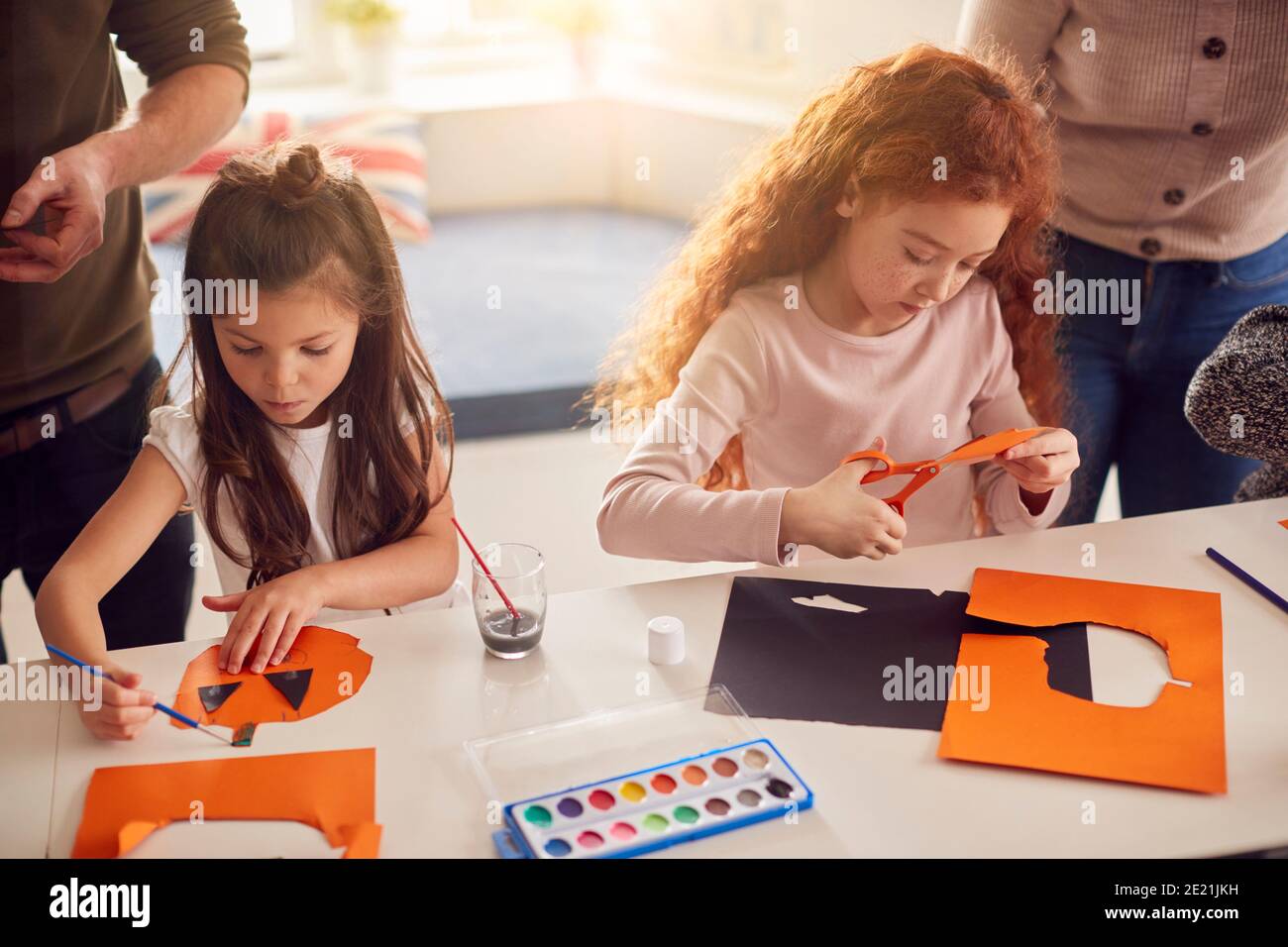 Two Girls At Home With Parents Having Fun Making Craft Together Stock ...