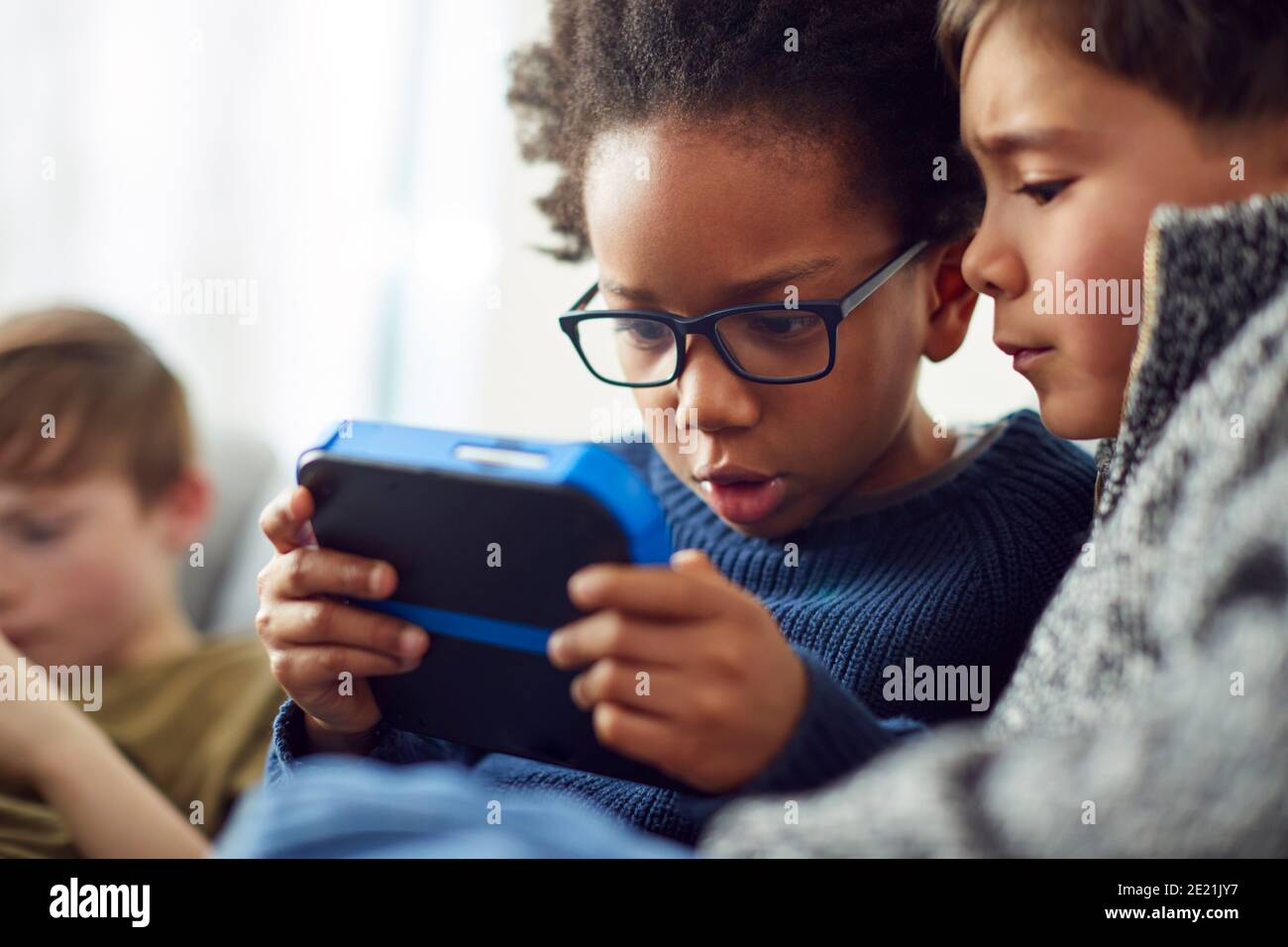 Group Of Young Boys Gaming Together On Hand Held Devices At Home Stock ...