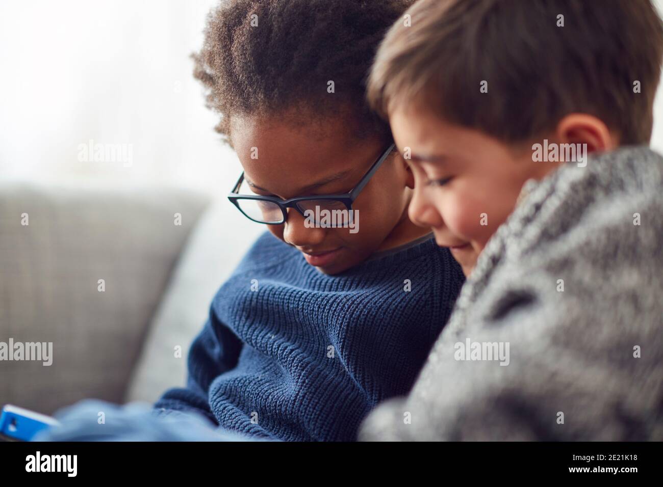 Two Boys Gaming Together On Hand Held Devices At Home Stock Photo - Alamy