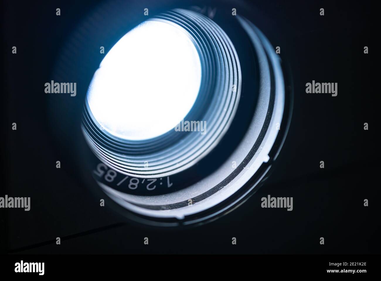 Close up image of a vintage film and slide projector lens on a dark ...