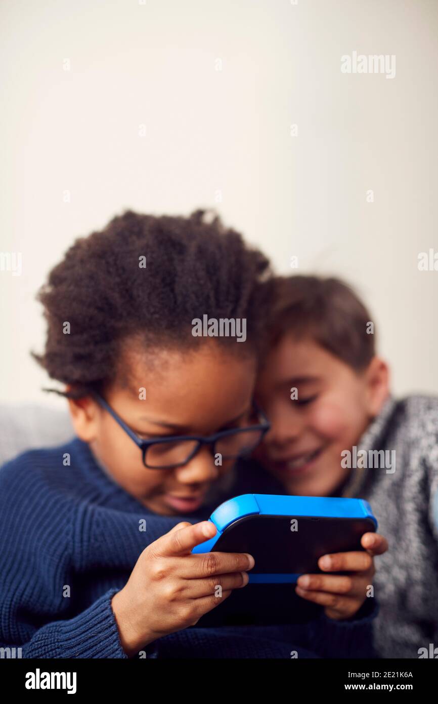 Two Boys Gaming Together On Hand Held Devices At Home Stock Photo - Alamy