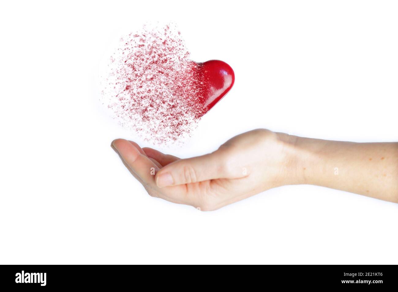Red love heart dispersing levitating upon an outstretched female hand ...