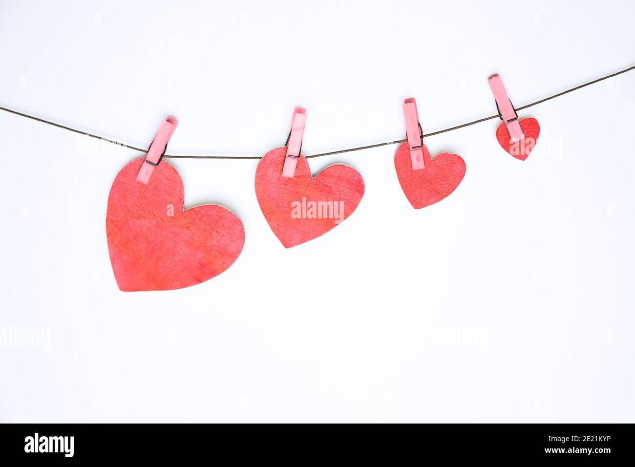 Several hearts of diferent sizes hanging in a clothes line against ...