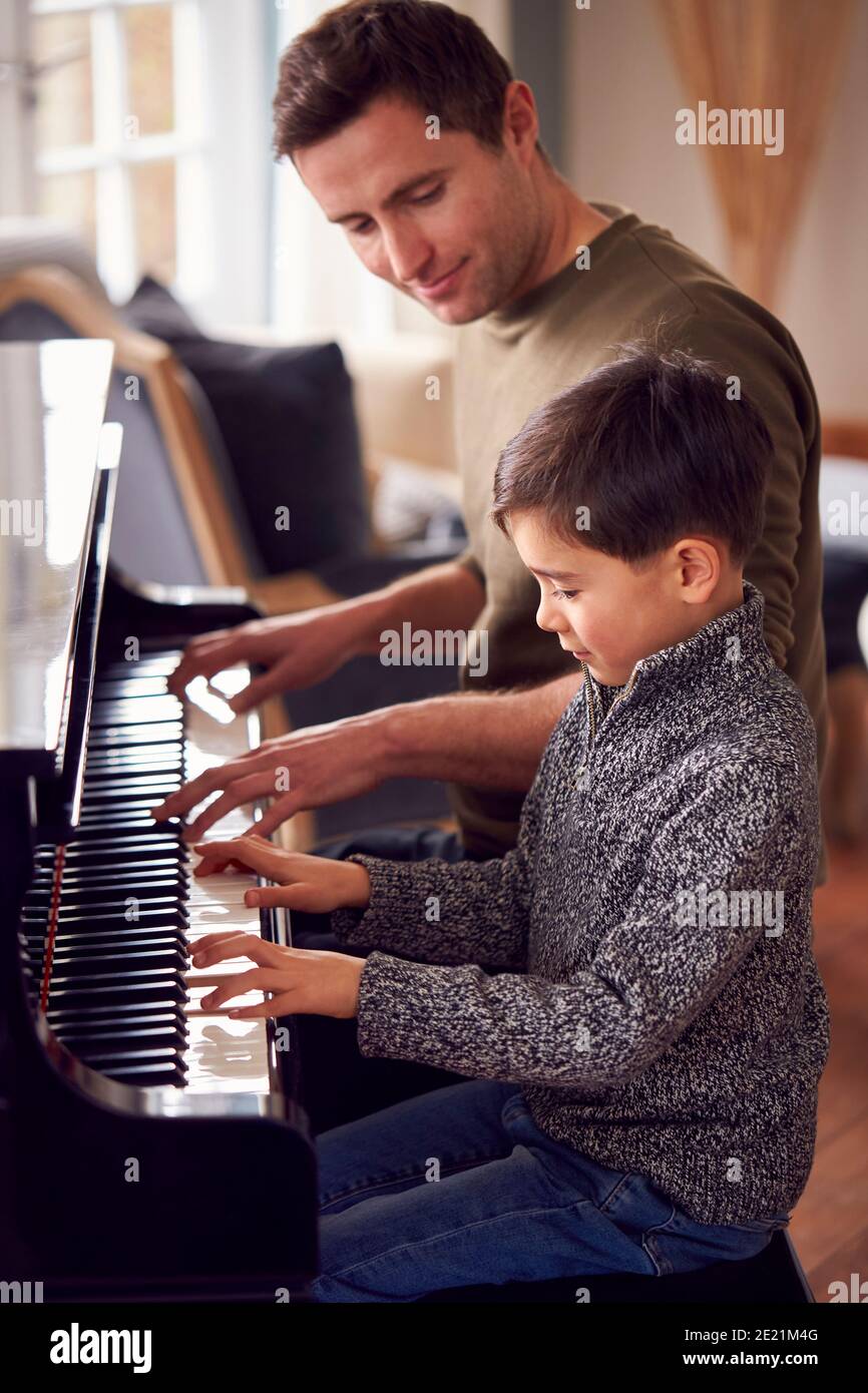 Young Boy Learning To Play Piano Having Lesson From Male Teacher Stock ...