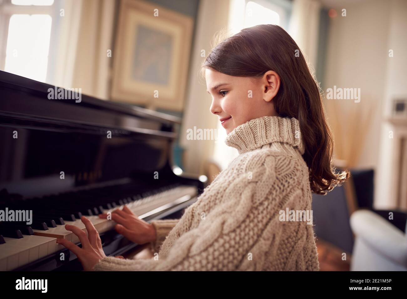 Young Girl Learning To Play Piano Practising At Home Stock Photo - Alamy
