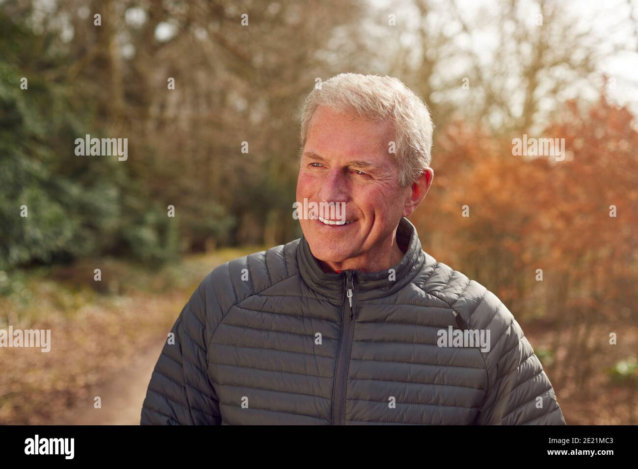 Smiling Senior Man On Walk In Autumn Countryside Exercising During ...