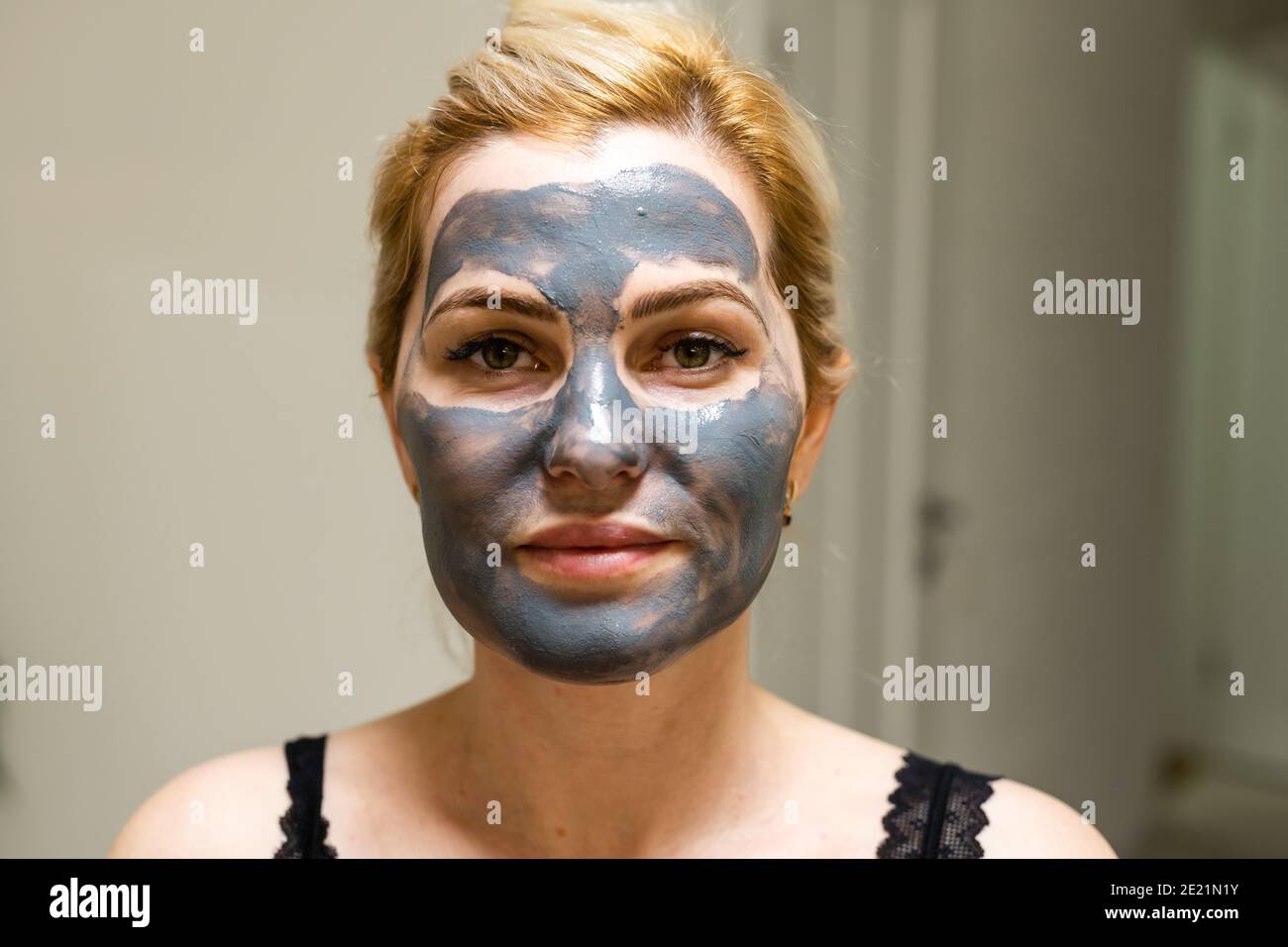 Beautiful woman with a clay or a mud mask on her face over white ...