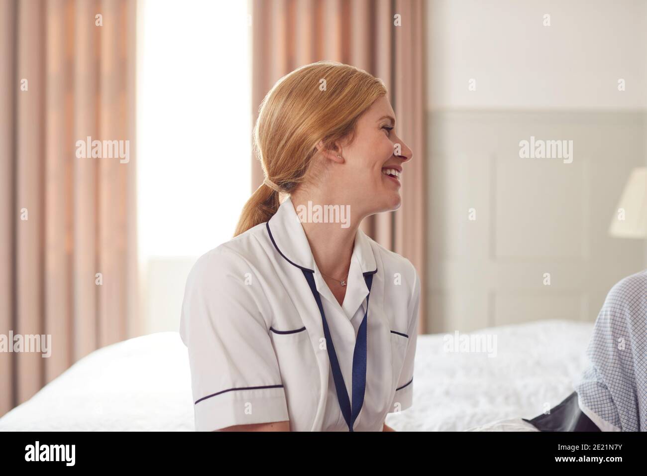 Smiling Female Doctor Making Home Visit To Patient In Bedroom Stock ...