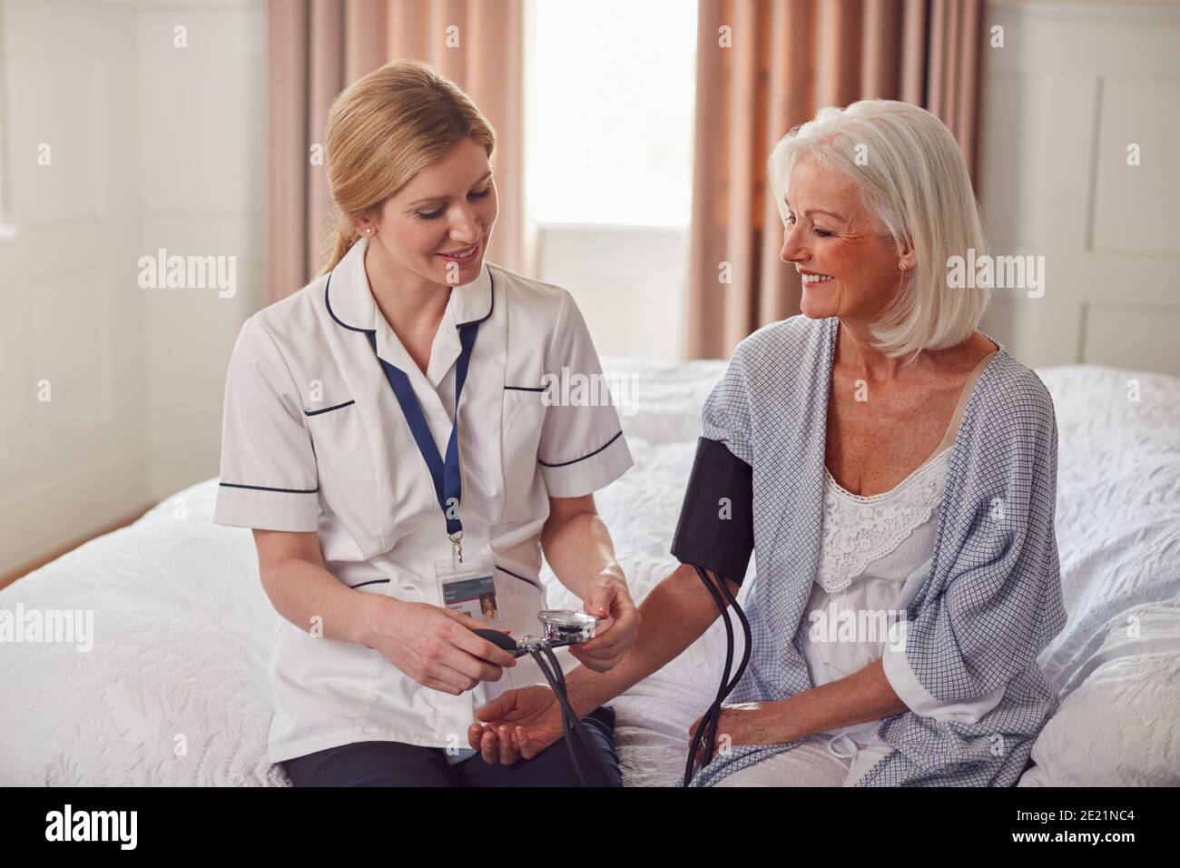 Female Doctor Making Home Visit To Senior Woman In Bedroom For Blood ...