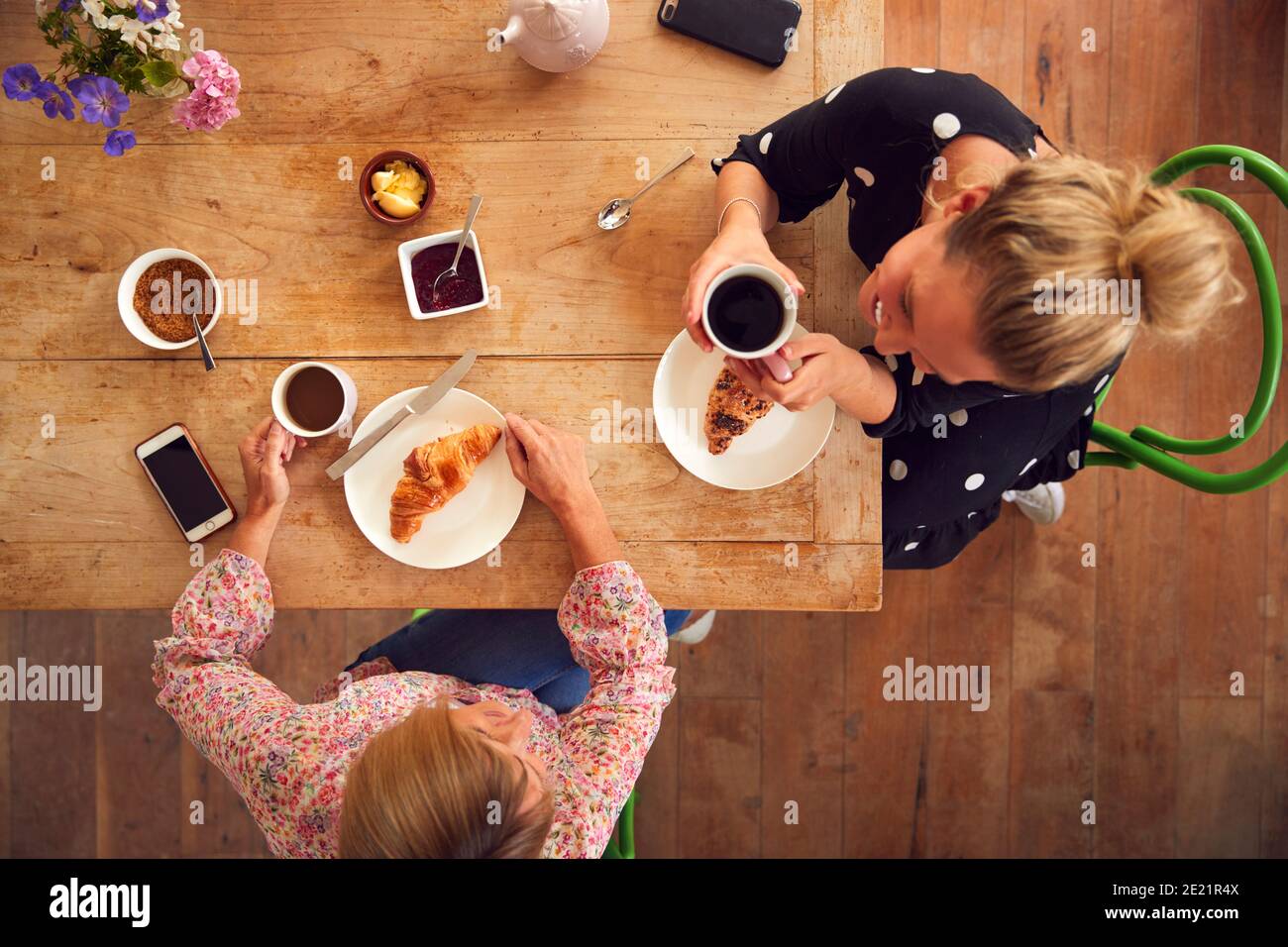 Overhead View Of Two Female Friends In Coffee Shop Meeting Up In ...