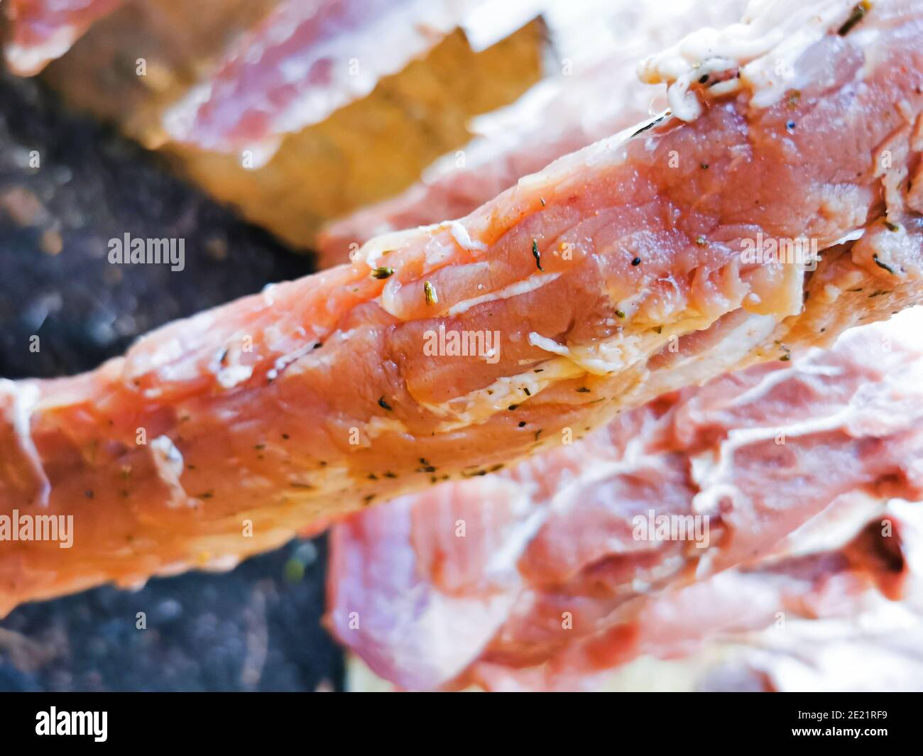 Raw pork meat seasoned and hanged for the smoking process Stock Photo ...