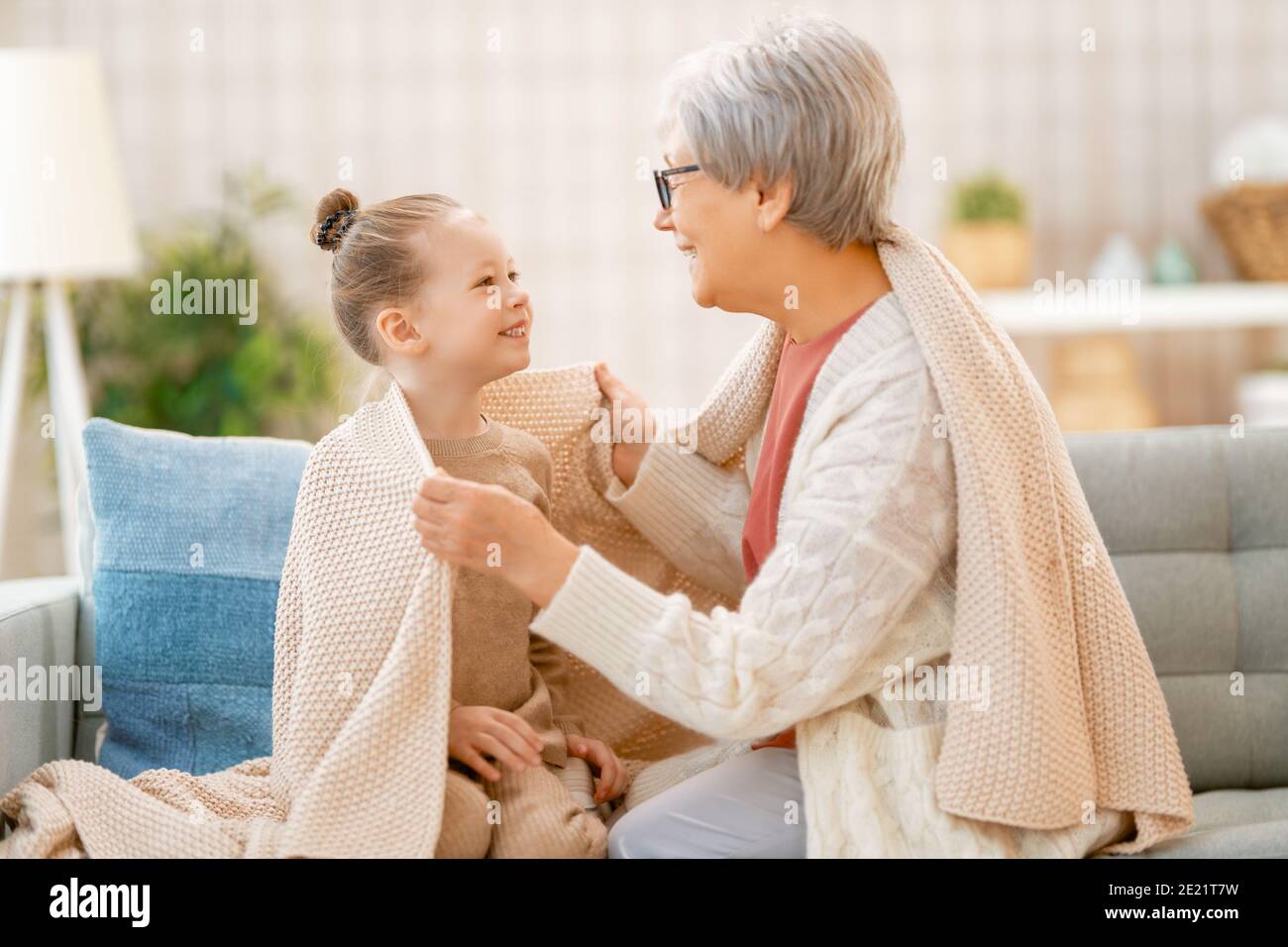 A nice girl and her grandmother enjoy sunny morning. Good time at home ...