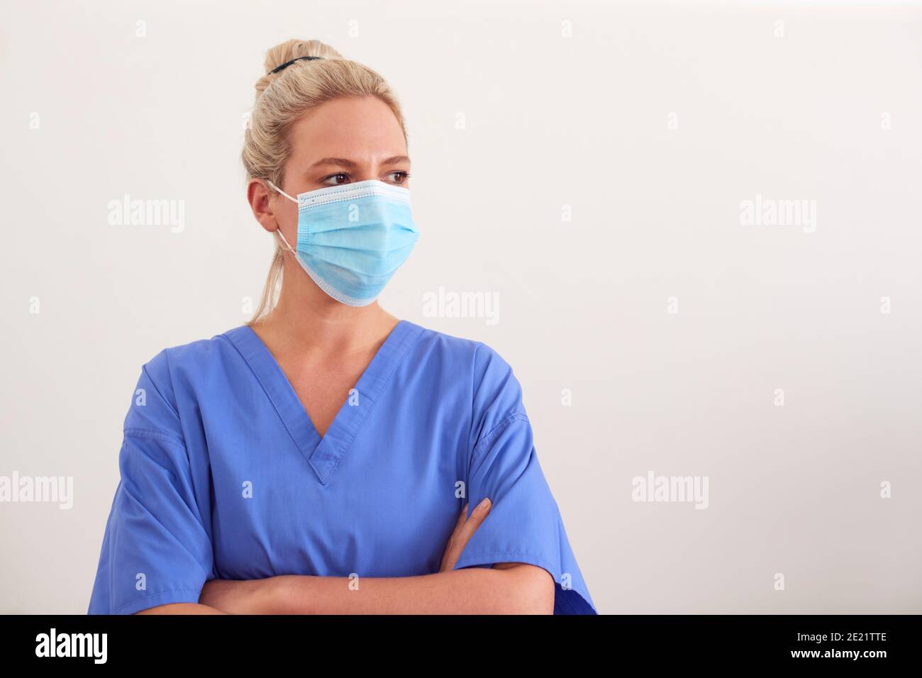 Studio Portrait Of Female Nurse Wearing Scrubs And PPE Face Mask ...