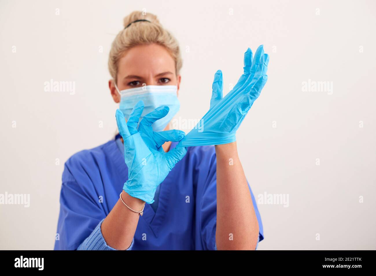 Studio Portrait Of Female Nurse Wearing Scrubs And PPE Face Mask ...