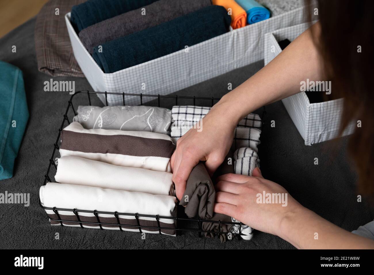 Vertical storage of clothing.Women organize clothes in a modern bedroom ...