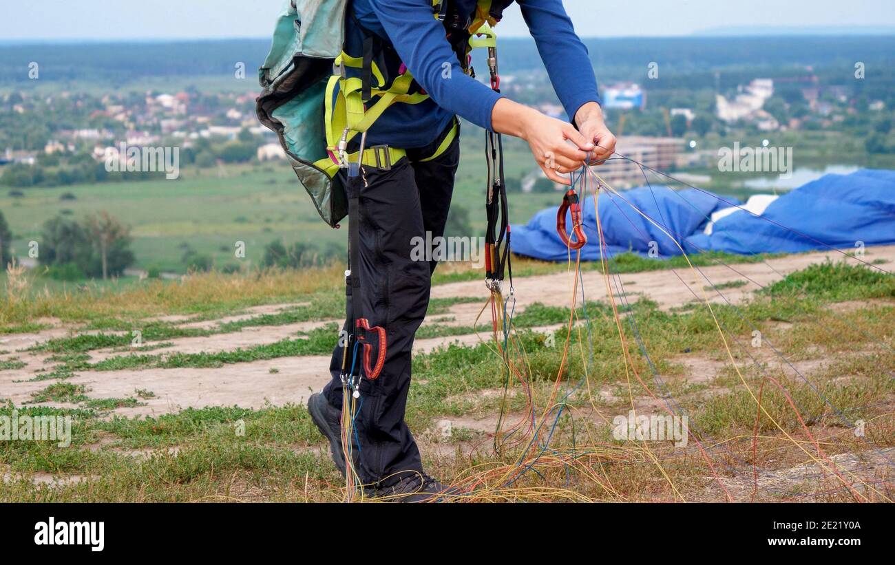 Male parachutst folding and preparing his parachute before jump ...