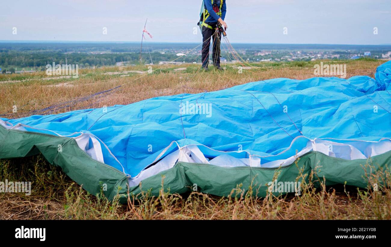 Closeup image of parachute wing lying on grass on field after ...