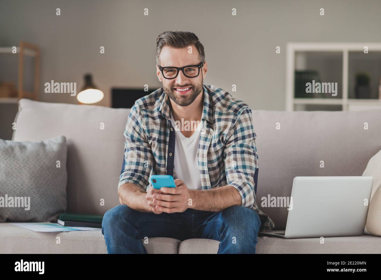 Photo of young cheerful handsome man happy positive smile sit sofa ...