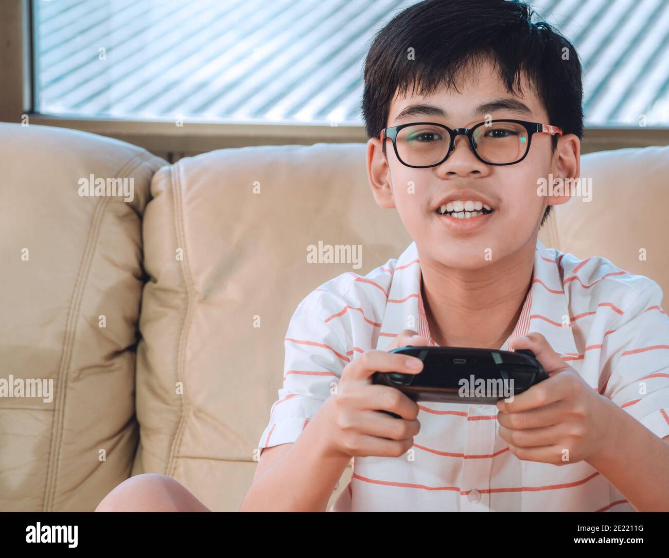 Excited asian boy are playing game console, controller or videogame ...