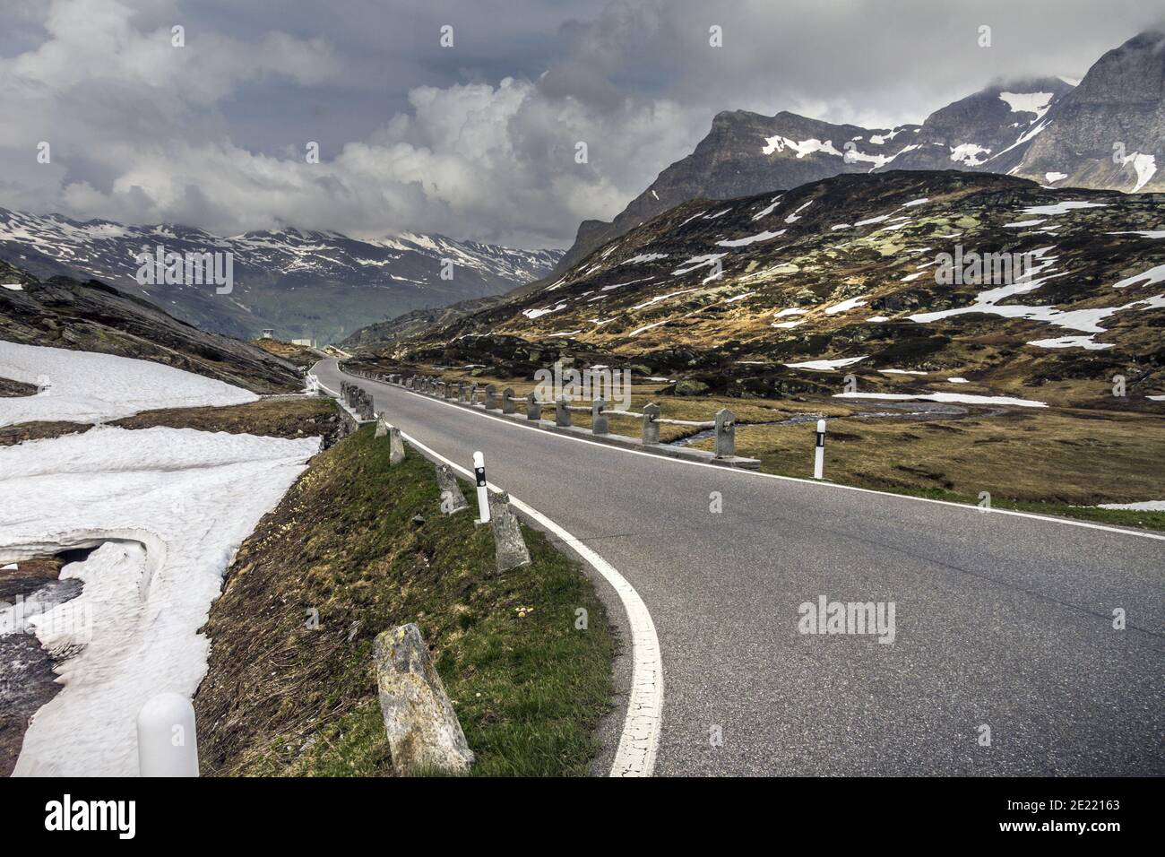 Curvy paved road going through beautiful nature scenes under a rainy ...