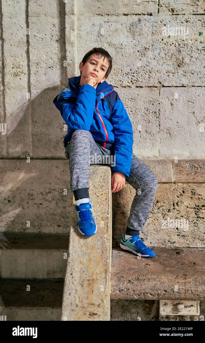 Cute Caucasian boy wearing a jacket and posing seriously Stock Photo - Alamy