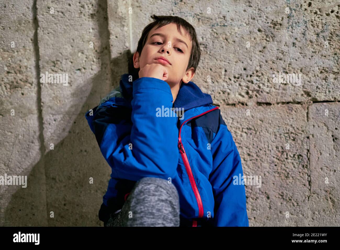 Cute Caucasian boy wearing a jacket and posing seriously Stock Photo - Alamy