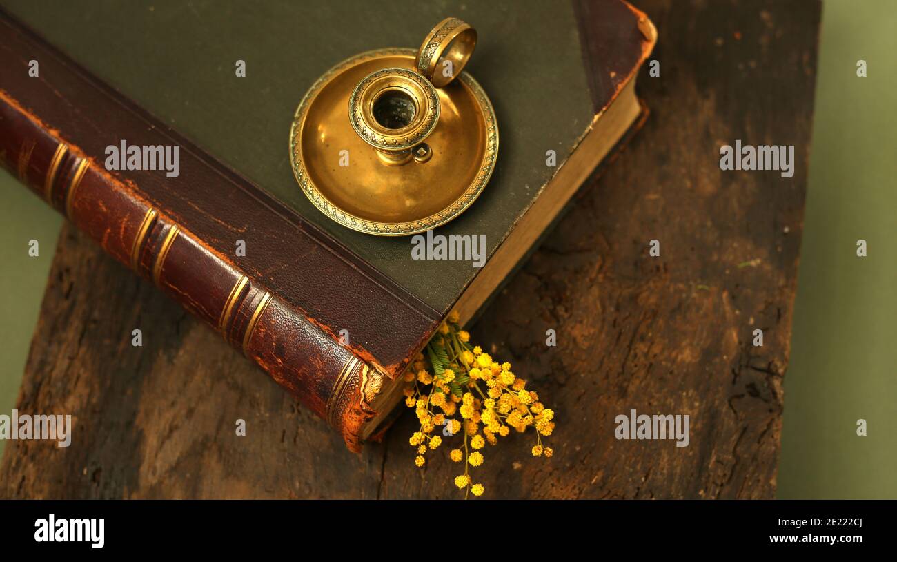 Old antique book with candlestick candle holder on old wood background ...