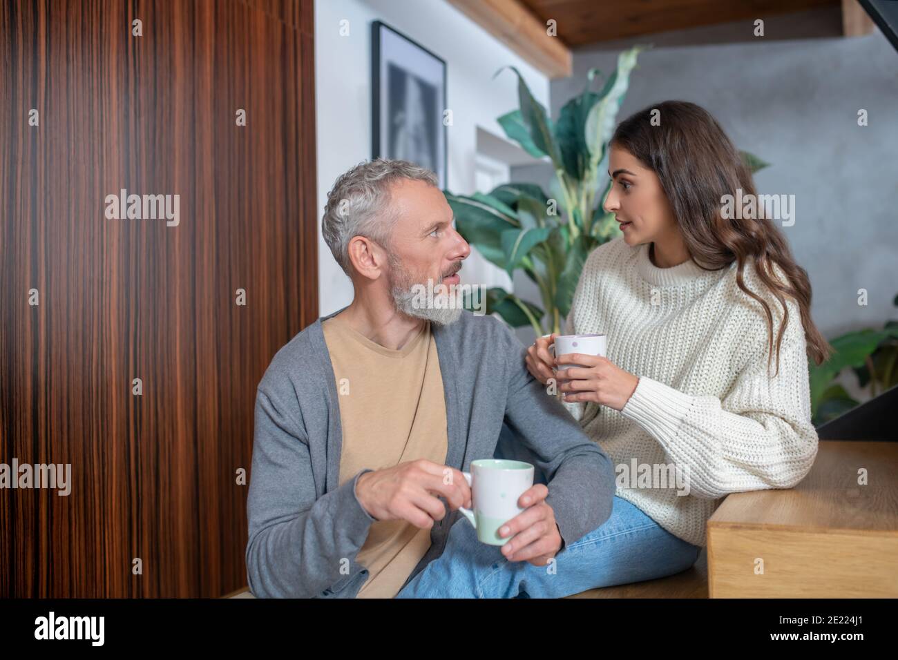 Married couple having coffee together and talking Stock Photo - Alamy