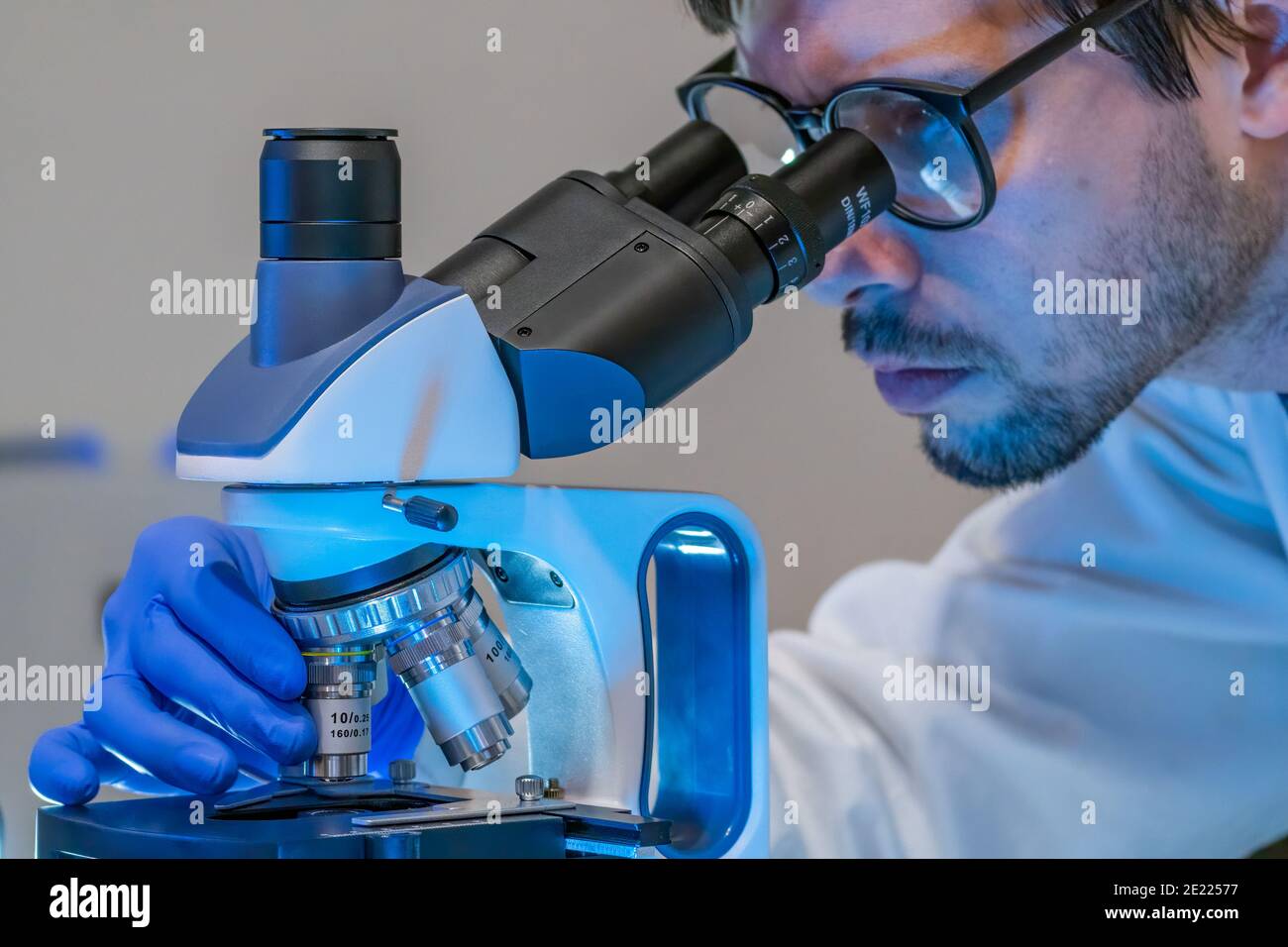 Scientist in laboratory is looking inside microscope. Microbiology and ...
