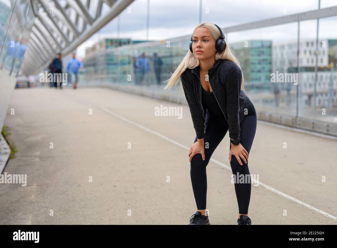Exhausted Female Runner Resting With Hands On Knees After Workout Stock ...