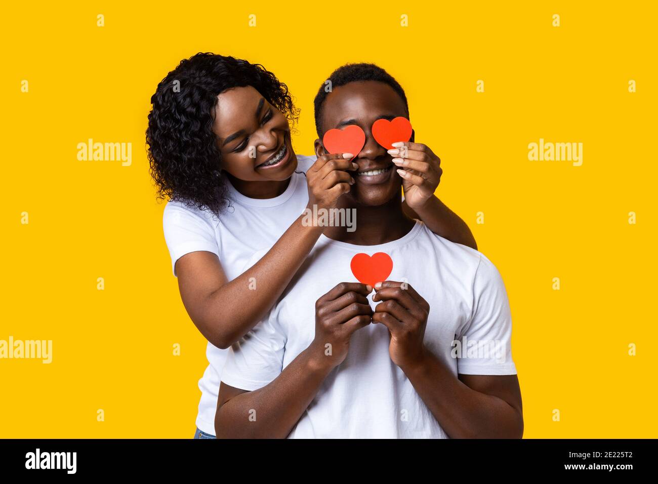 Loving black woman covering her boyfriend eyes with valentine cards ...