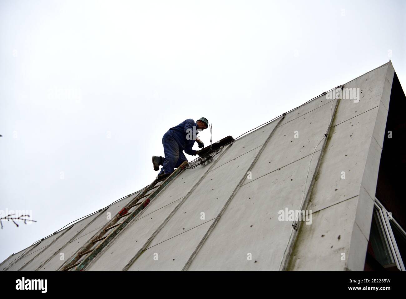 The Roof Roofer Climbs Up The Ladder To The Roof Of The House To Fix Sheet Metal Roof Stock 