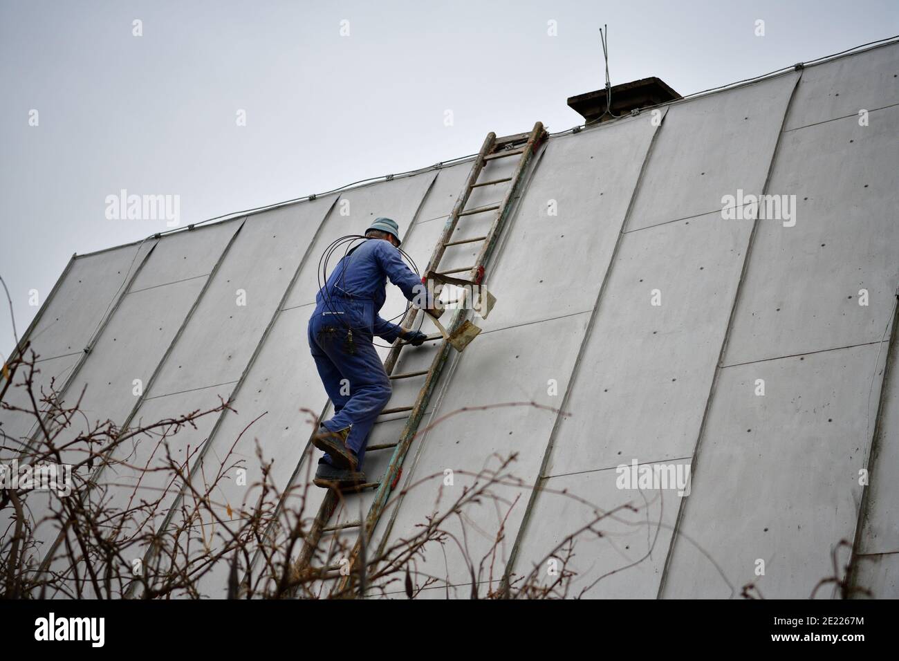 A chimney sweep climbs a ladder to the roof to repair a chimney Stock ...