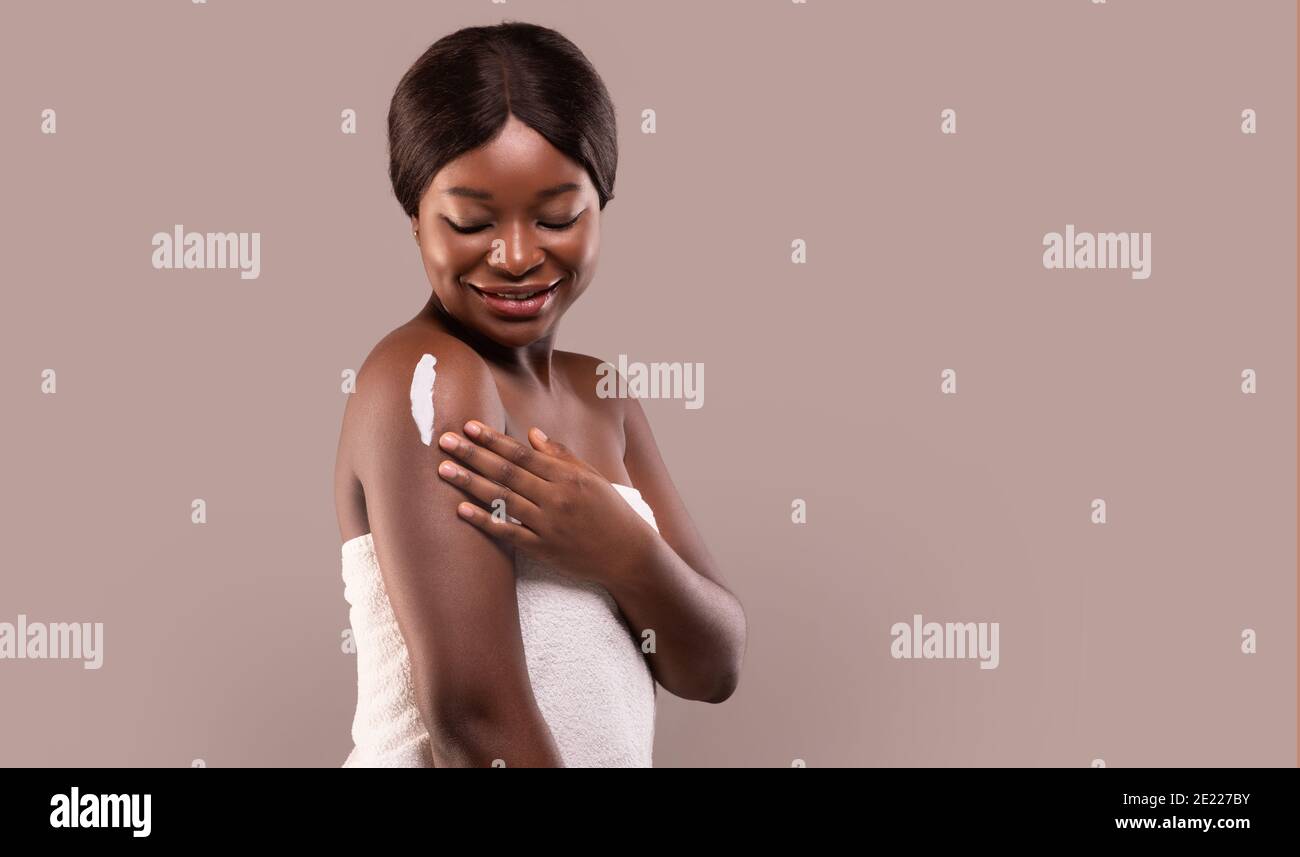African american woman applying lotion hi-res stock photography and ...