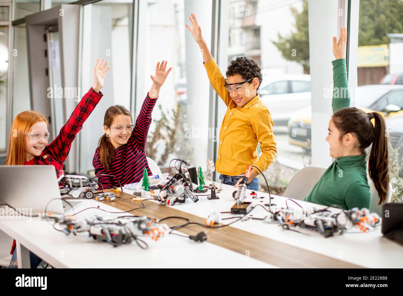 Group of happy kids programming electric toys and robots at robotics ...