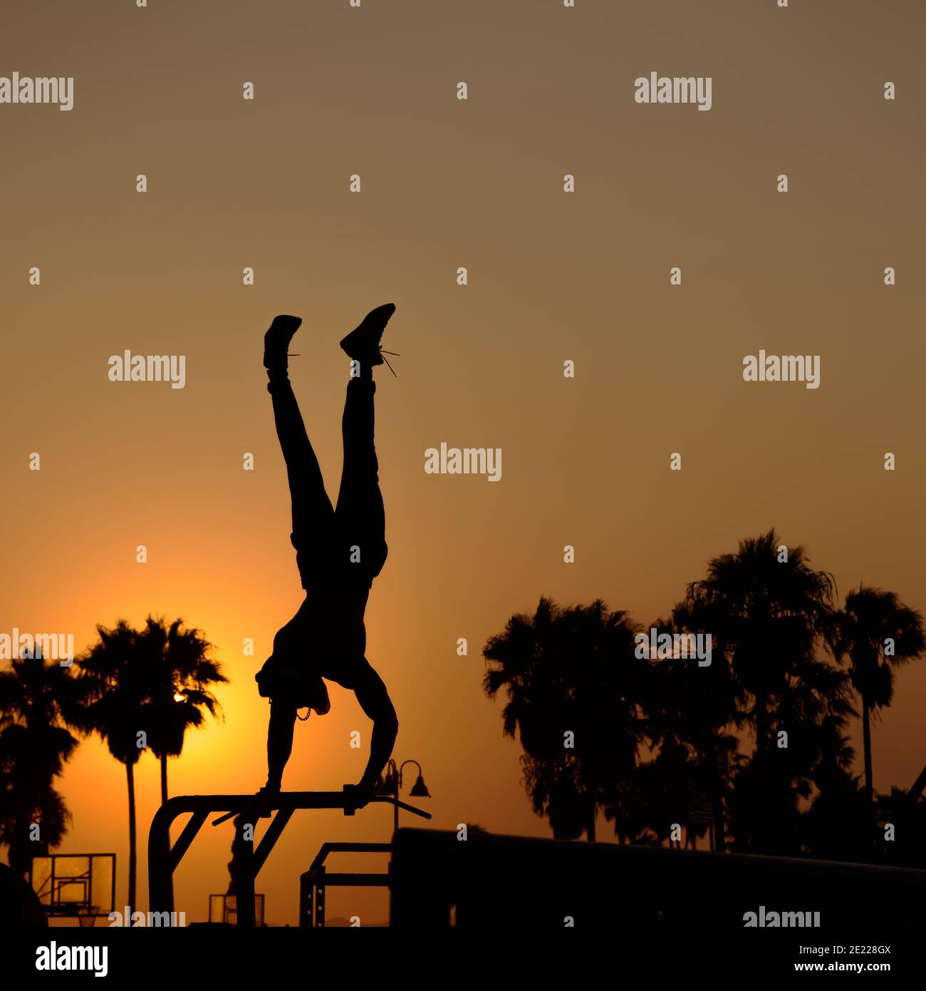 Vertical shot of a man silhouette balancing his body on hands in the ...
