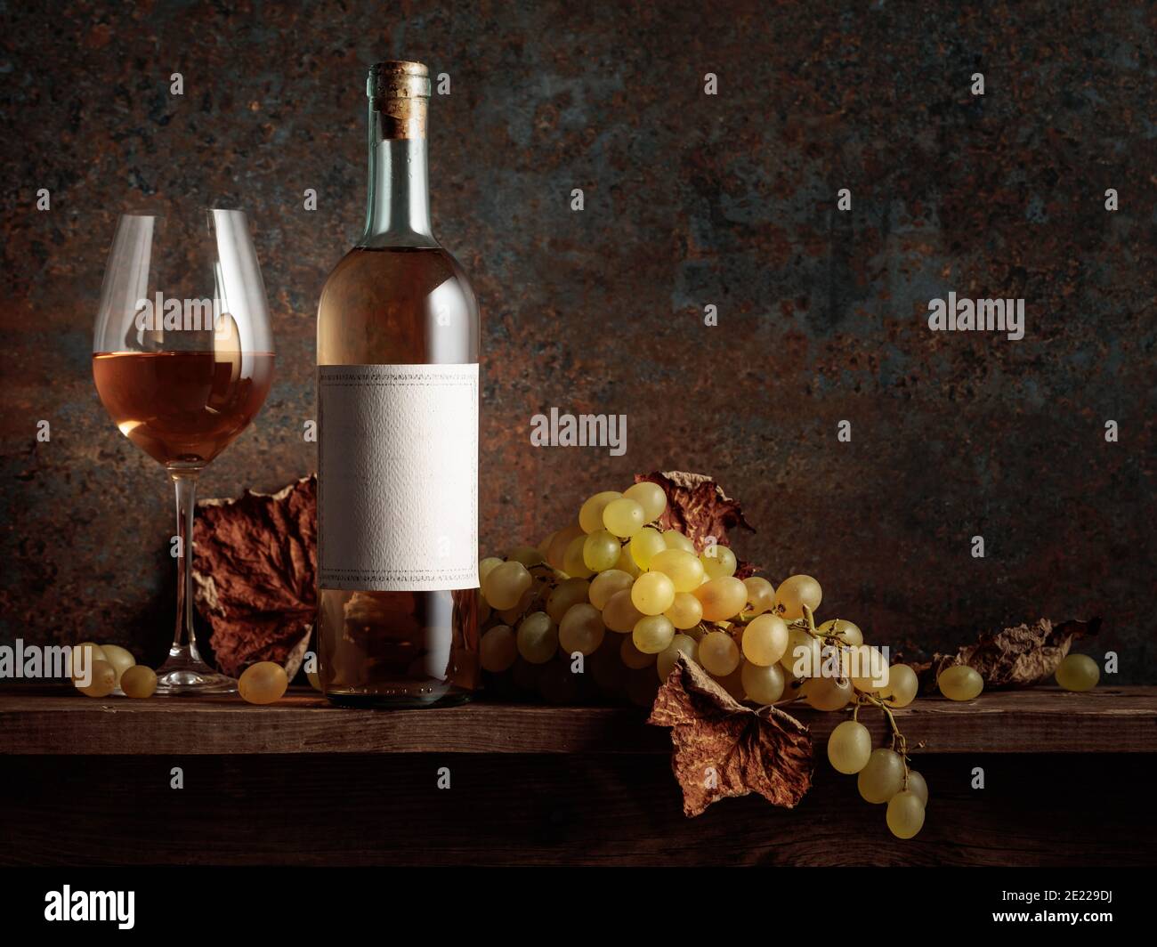 Wine with grapes and dried up vine leaves. Bottle with old empty label ...