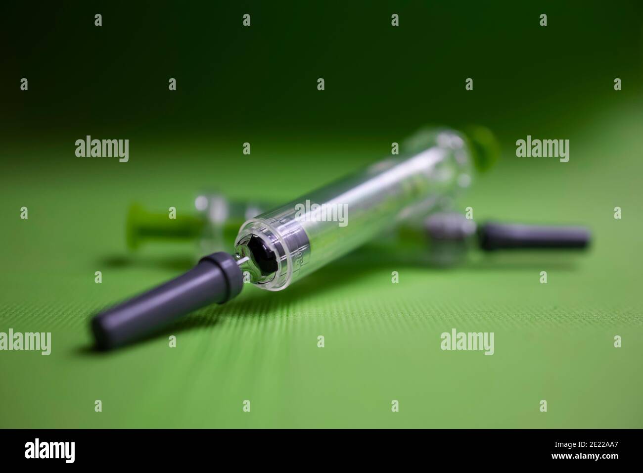 Syringe on a green background Stock Photo - Alamy