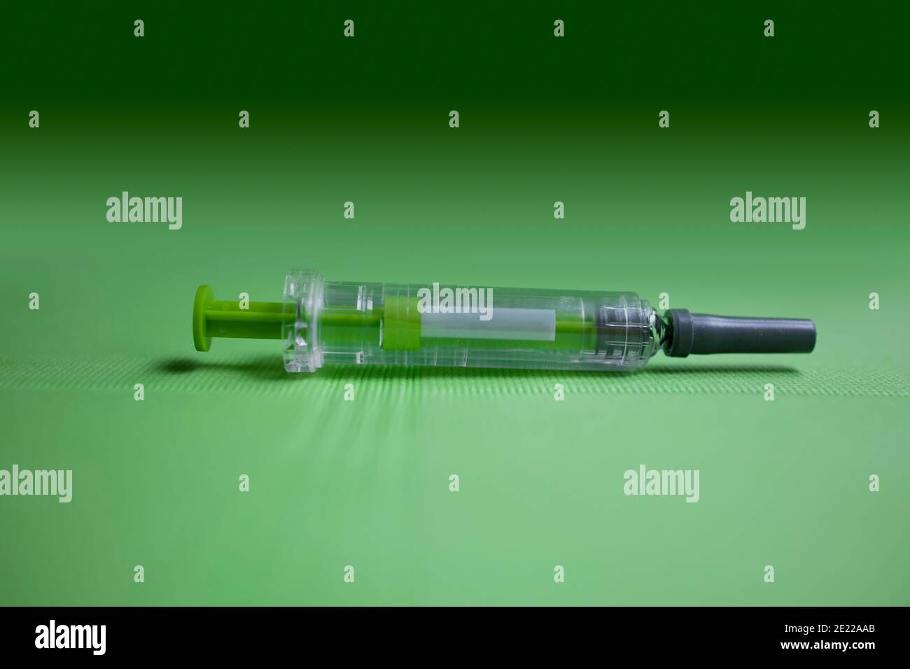 Syringe on a green background Stock Photo - Alamy