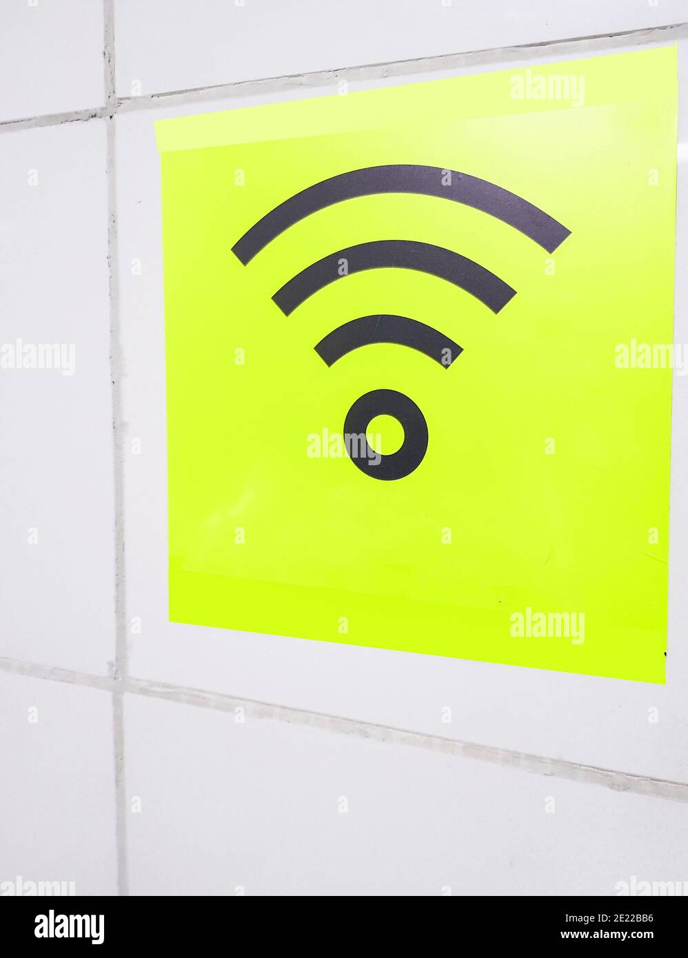 The zone symbol of the free Wi Fi, a yellow sign on a white wall in an ...