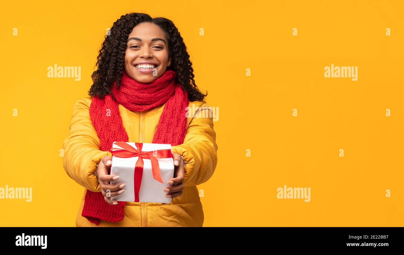 African Lady Giving Gift To Camera Over Yellow Background, Panorama ...