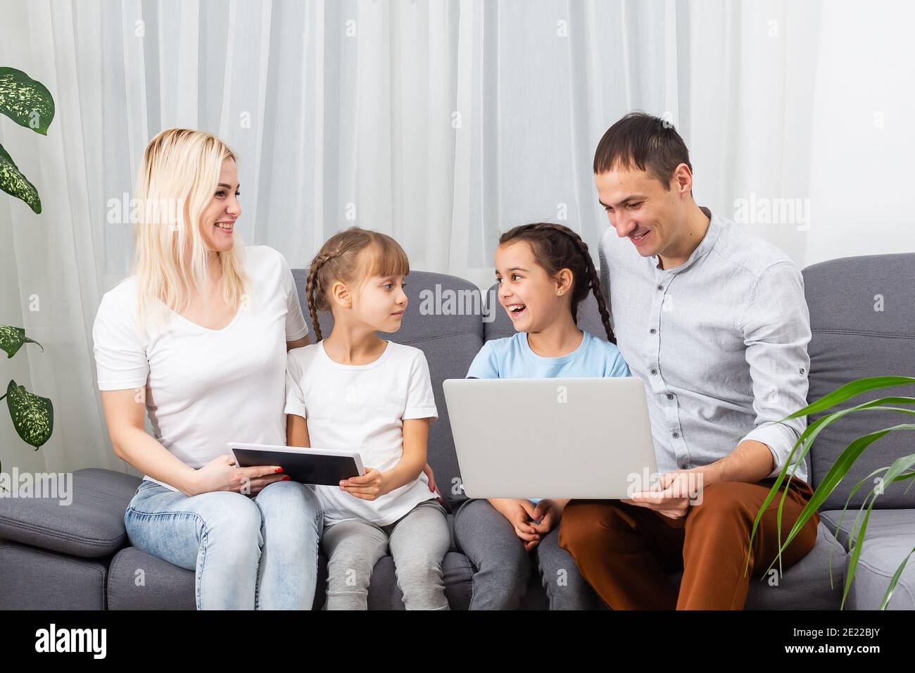 Young parents, with children, on laptop computer Stock Photo - Alamy