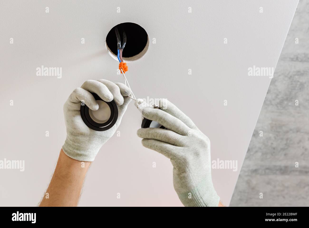 An electrician is installing LED spotlights on the ceiling Stock Photo ...