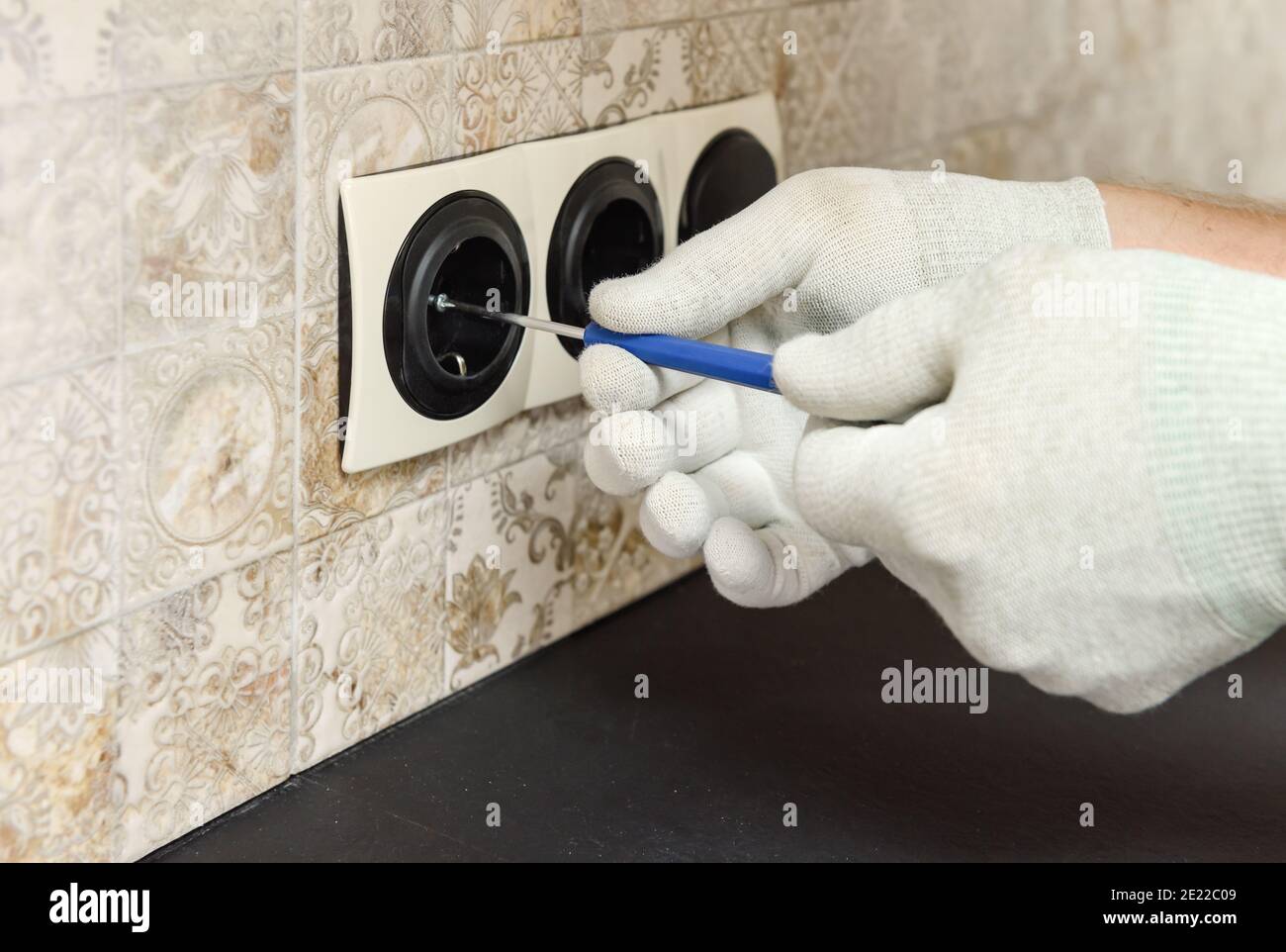 An electrician is installing switches and sockets on the wall Stock ...