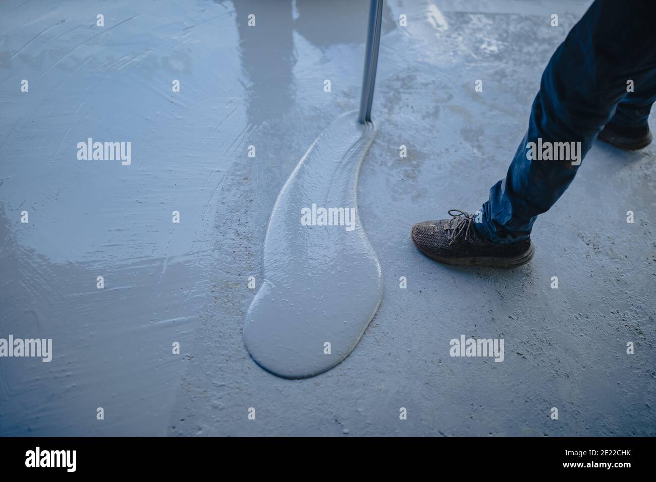 The worker applies gray epoxy resin to the new floor Stock Photo - Alamy