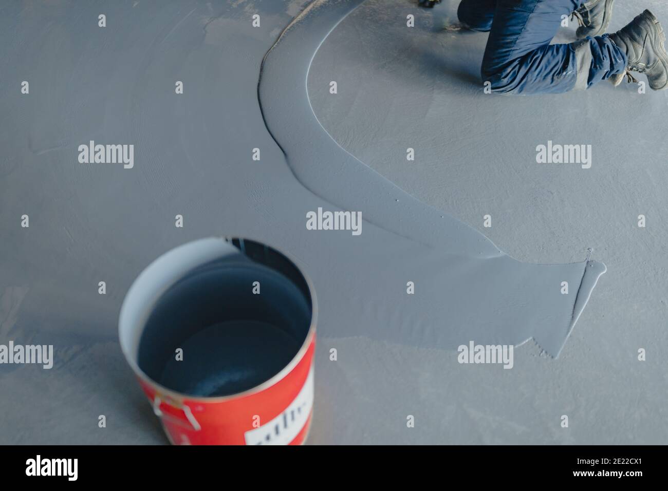 The worker applies gray epoxy resin to the new floor Stock Photo - Alamy