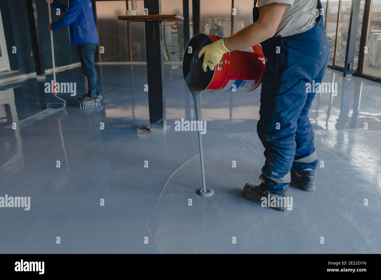 The worker applies gray epoxy resin to the new floor Stock Photo - Alamy